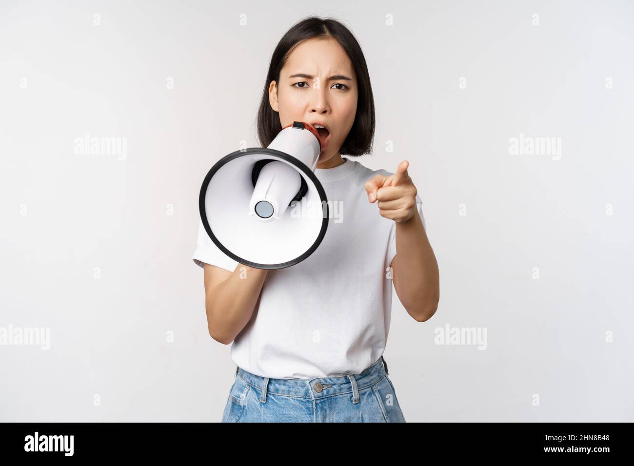 Angry asian woman with megaphone, scolding, accusing someone ...