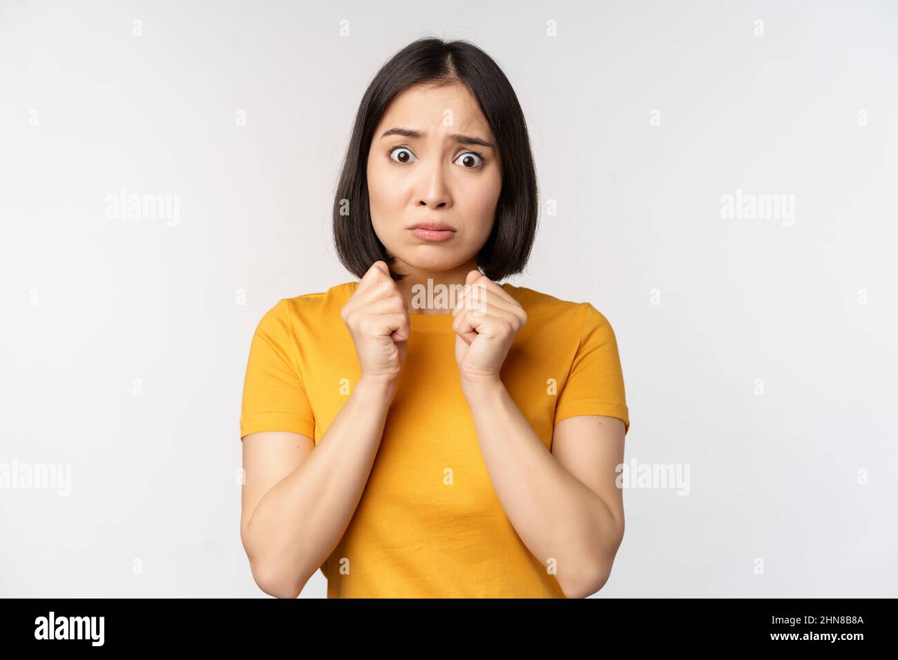 Portrait of scared asian woman shaking from fear, looking terrified and ...