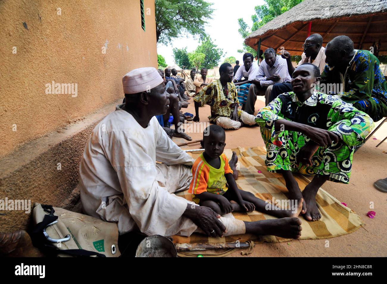 Mossi chief sitting with the village elderly men in his small village ...