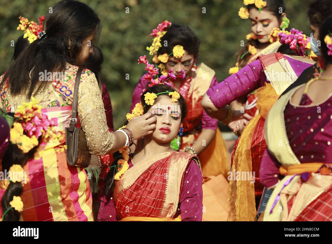 Women wearing traditional saris and flower crowns are seen during the ...