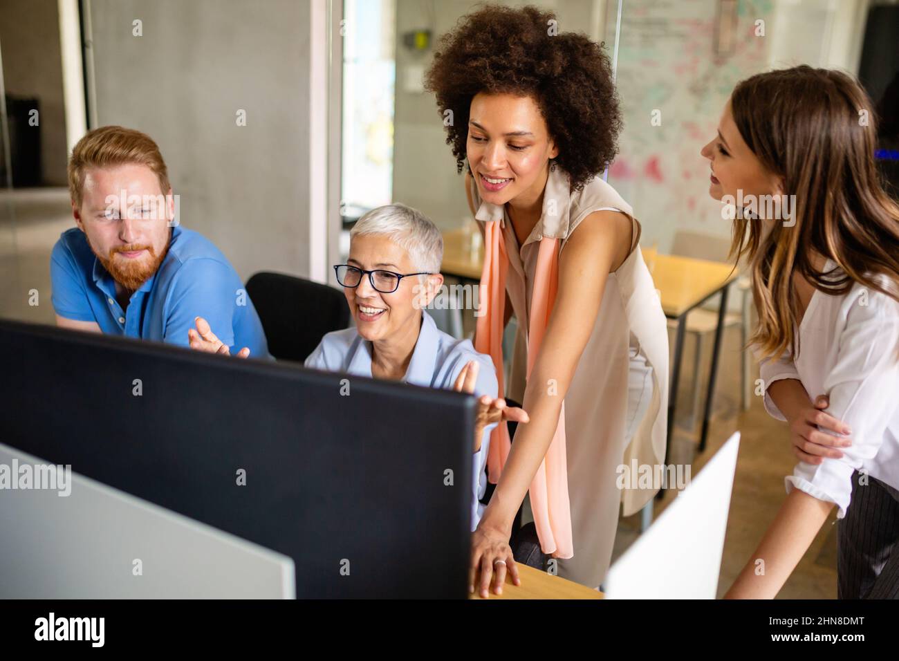 Group of software engineers working developing applications together in ...