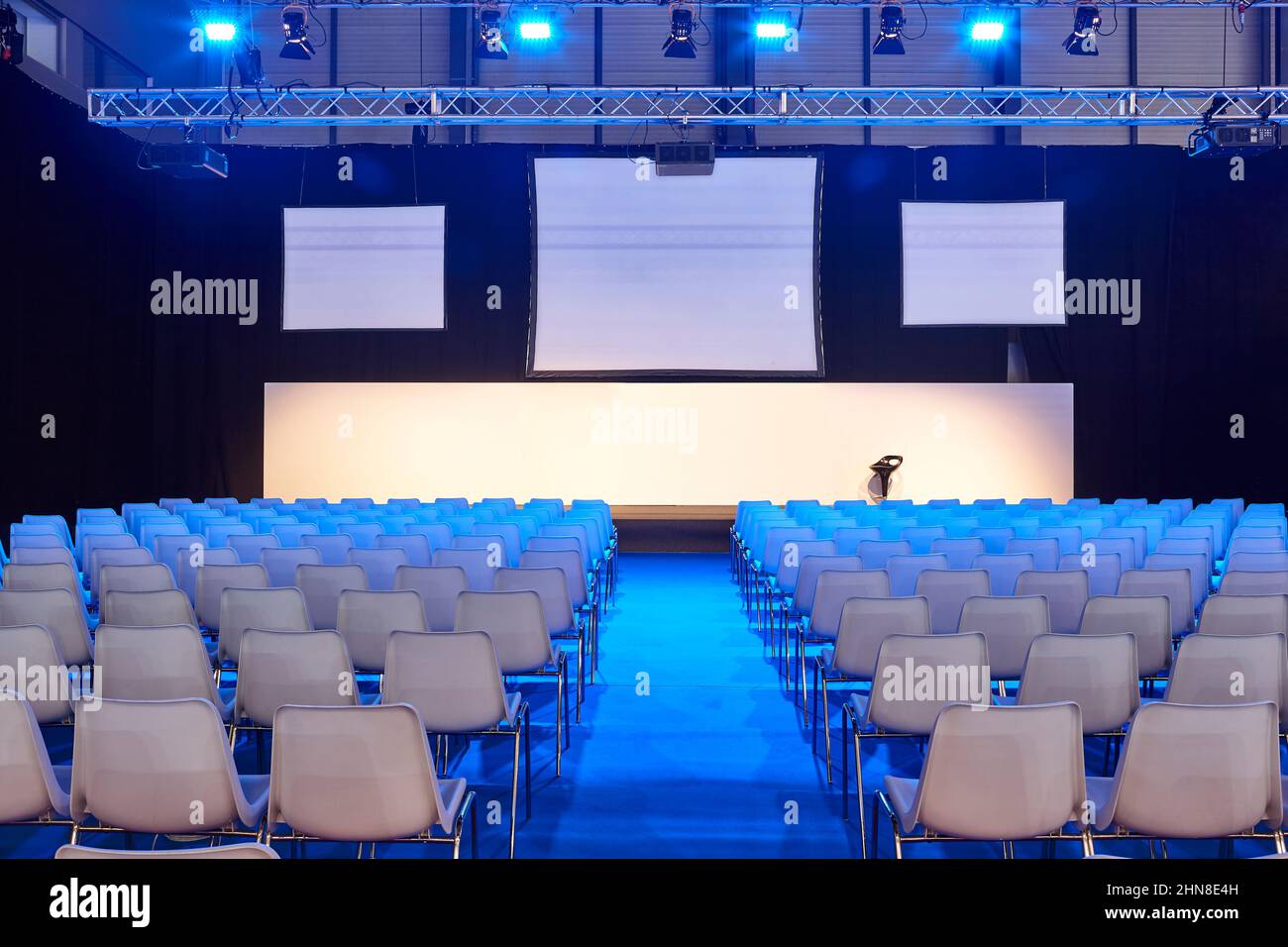 Conference room with video projectors, screens and platform ...