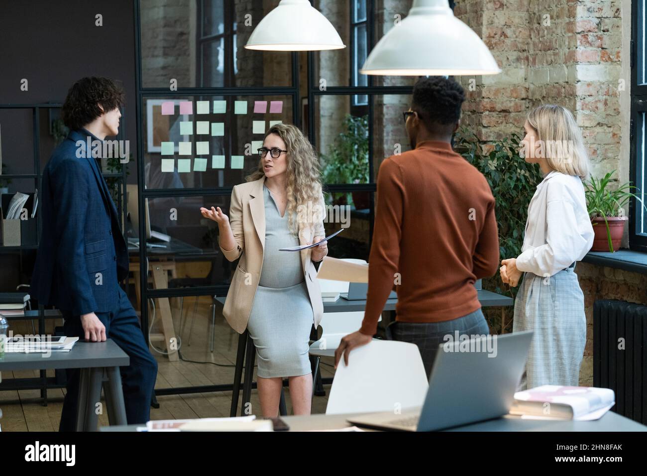 Pregnant businesswoman giving the tasks to employees before going to ...