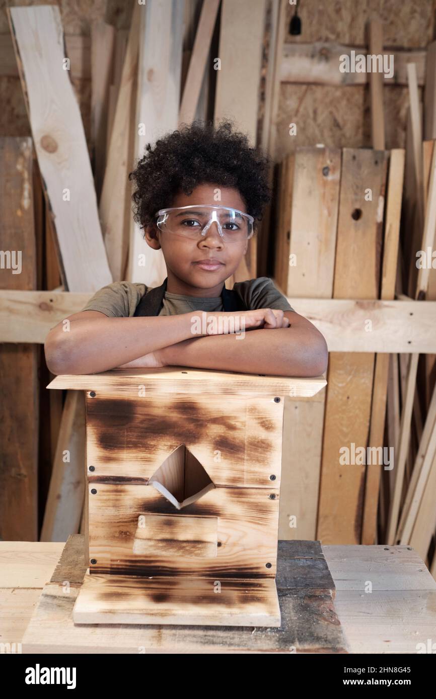 Vertical portrait of young black boy looking at camera while building ...