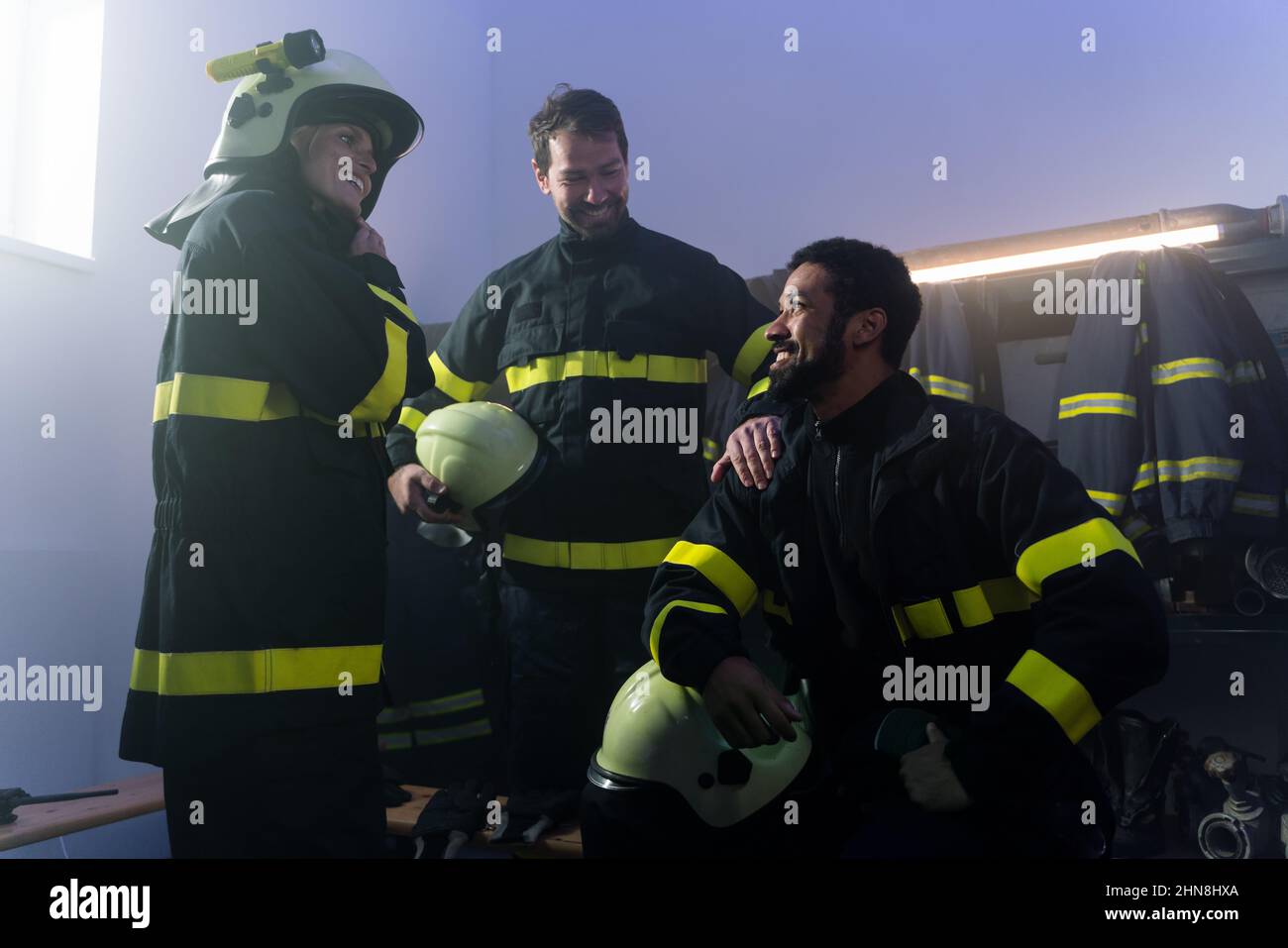 Happy firefighters men and woman talking after action indoors in fire ...