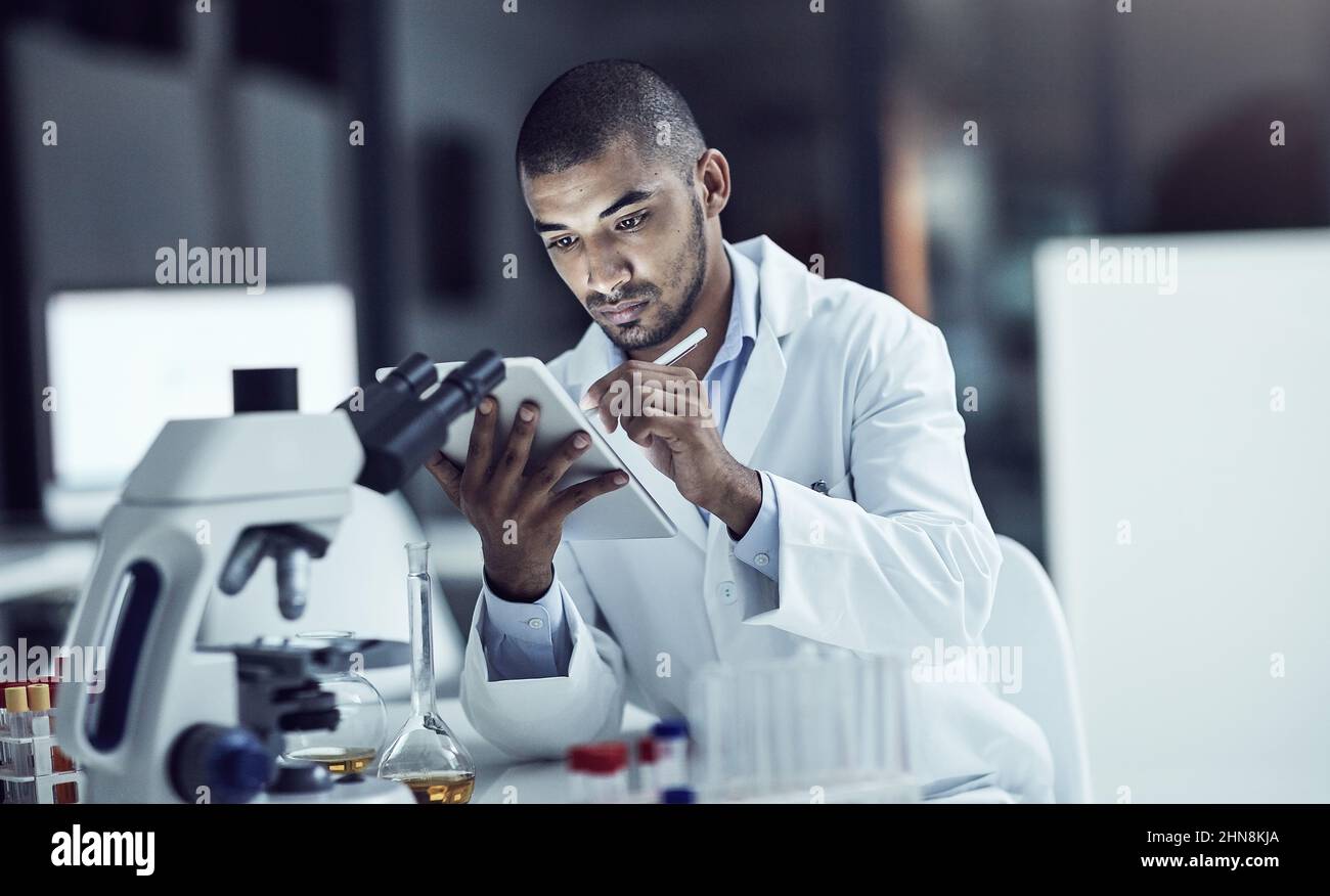 Organizing the test results. Shot of a scientist recording his findings ...