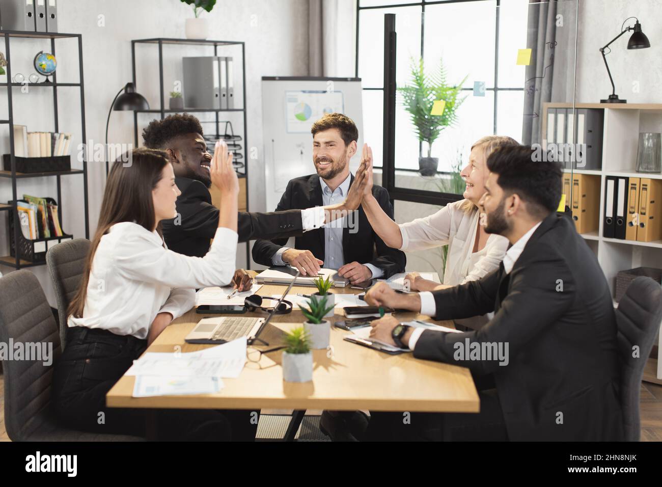 International team of business partners giving high five to each other ...
