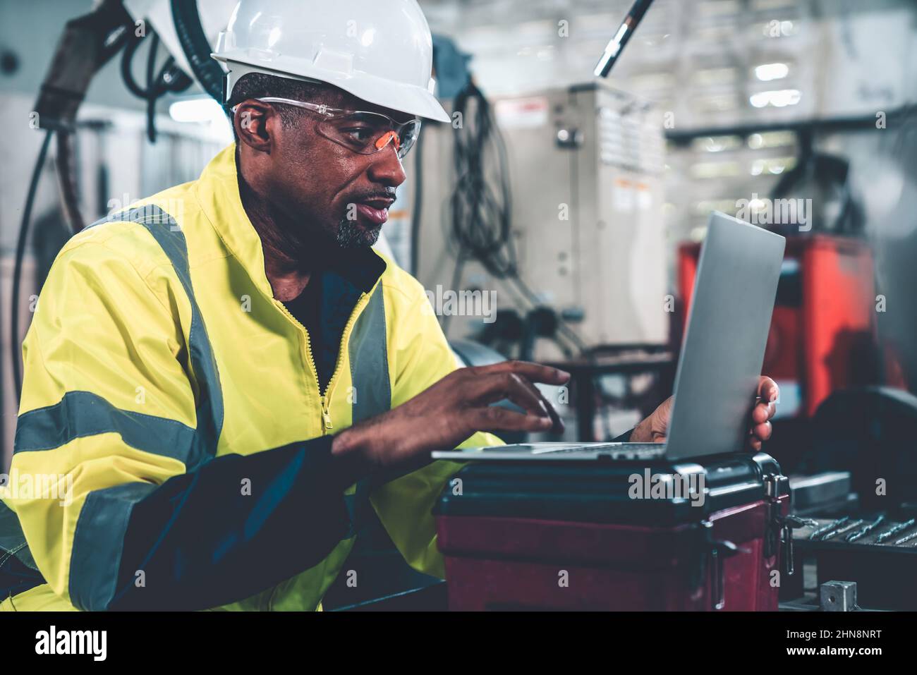 Factory worker working with laptop computer to do adept procedure ...