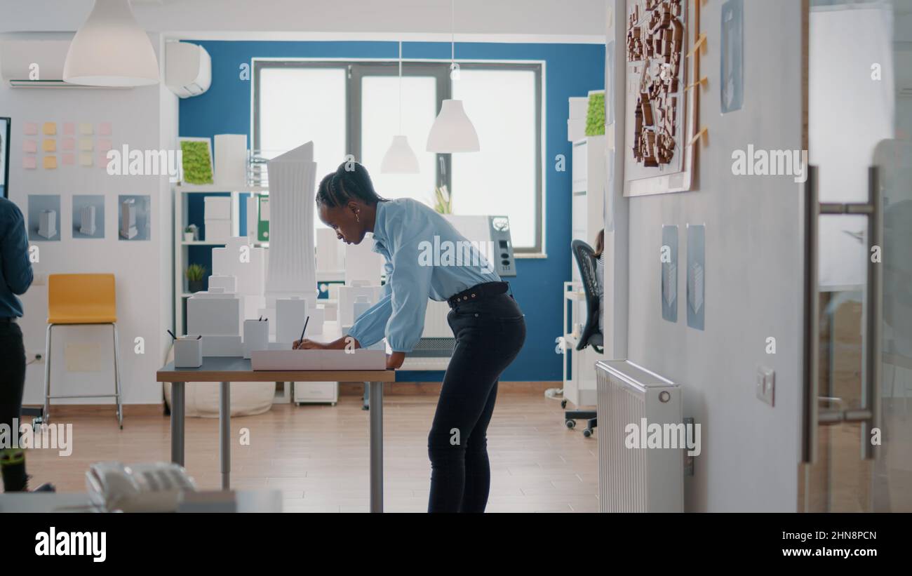 Woman architect working on blueprints plan to design construction ...