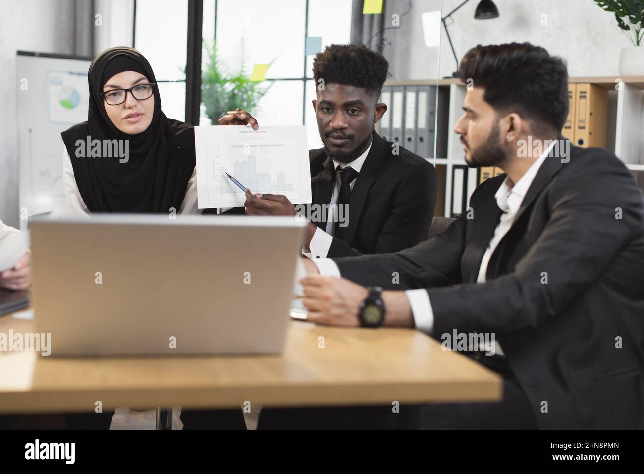 Multi ethnic group of business people using wireless laptop for video ...