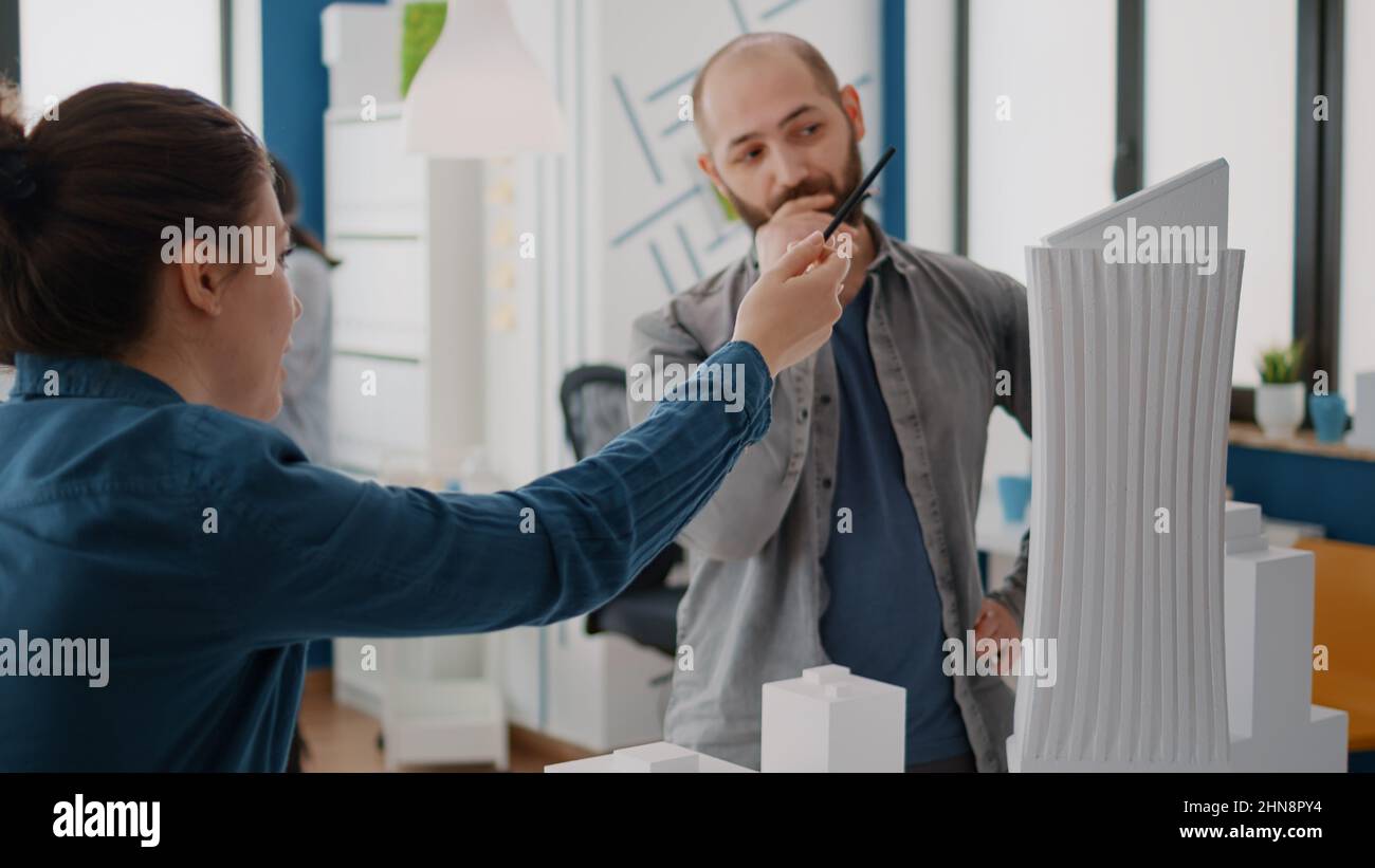Woman brainstorming ideas with man to design building model plan and ...