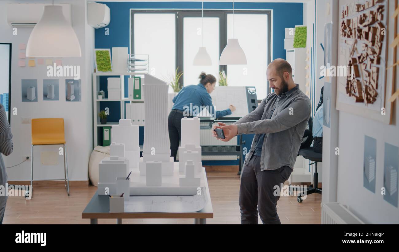 Man using smartphone to design building model and construction layout ...