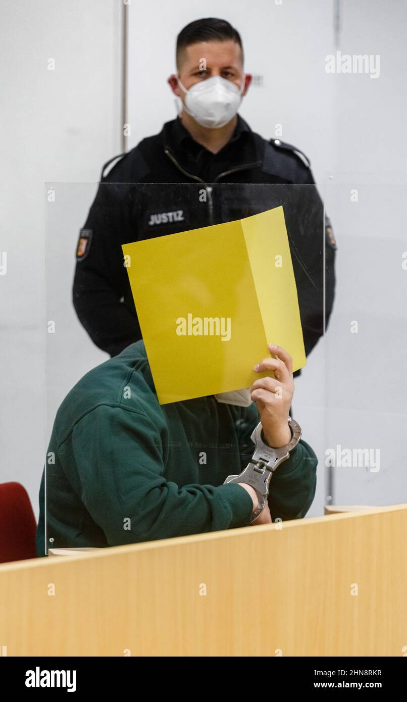 15 February 2022, Schleswig-Holstein, Lübeck: The defendant hides his ...