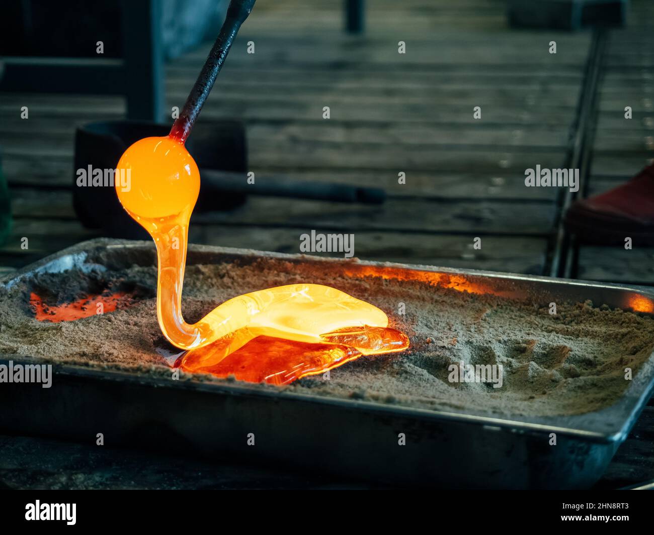 Creating traditional glass Art. Melting glass mould into sand form ...