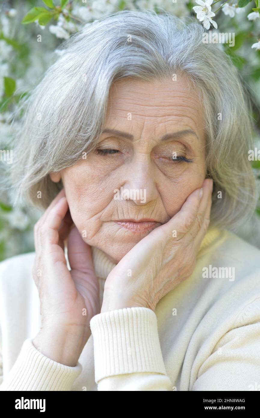 Portrait of sad senior beautiful woman in park Stock Photo - Alamy