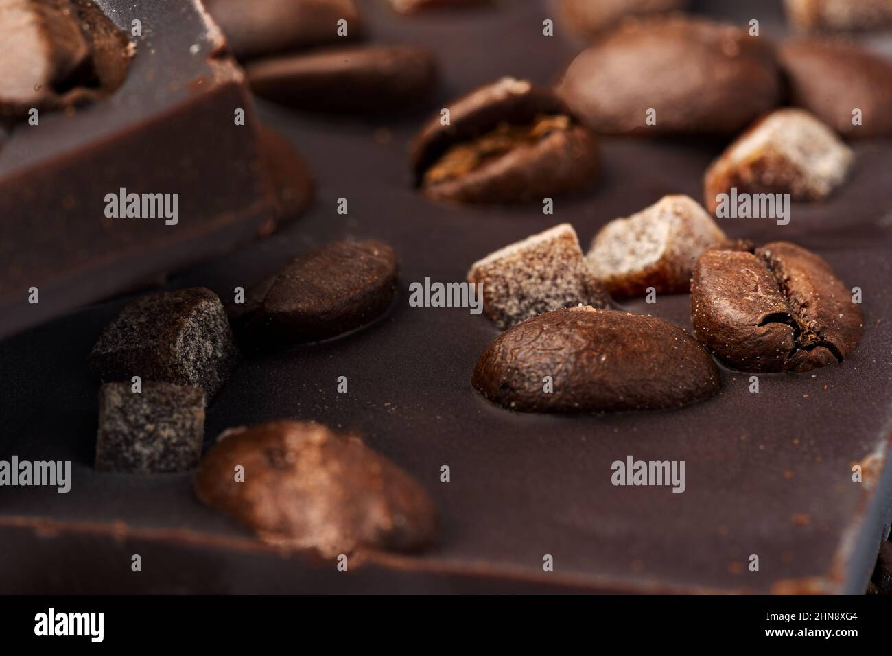 Close up of dark chocolate bar with coffee beans and candied fruit ...