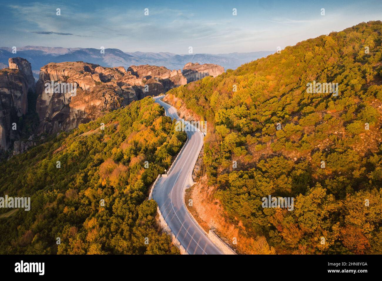 Aerial top view over scenic serpentine roads among dense forest near ...