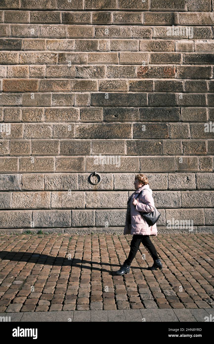 brick wall with a lady walking by Stock Photo - Alamy