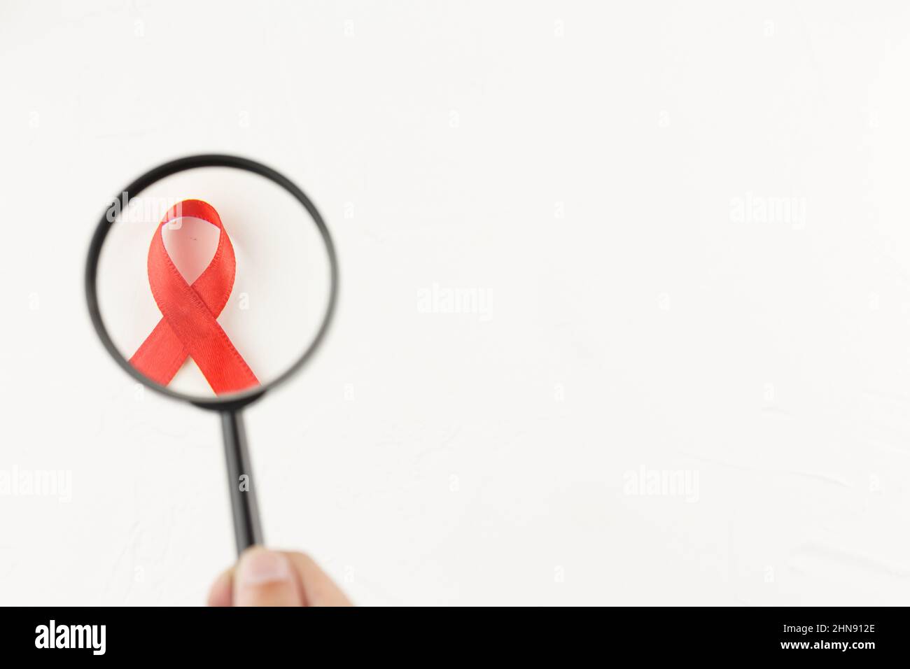 Cancer ribbon with magnifying glass Stock Photo - Alamy