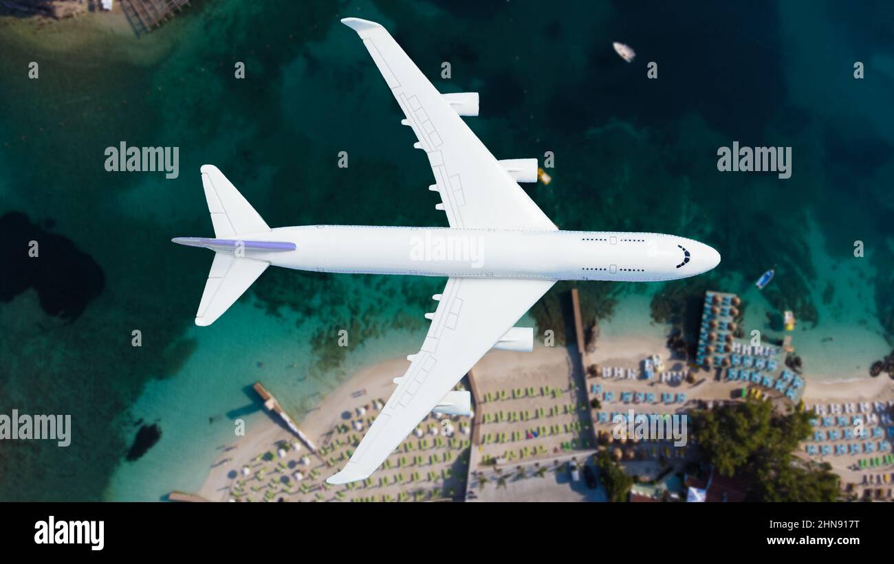 Aerial top down view of an airplane flying over blue sea as a travel ...