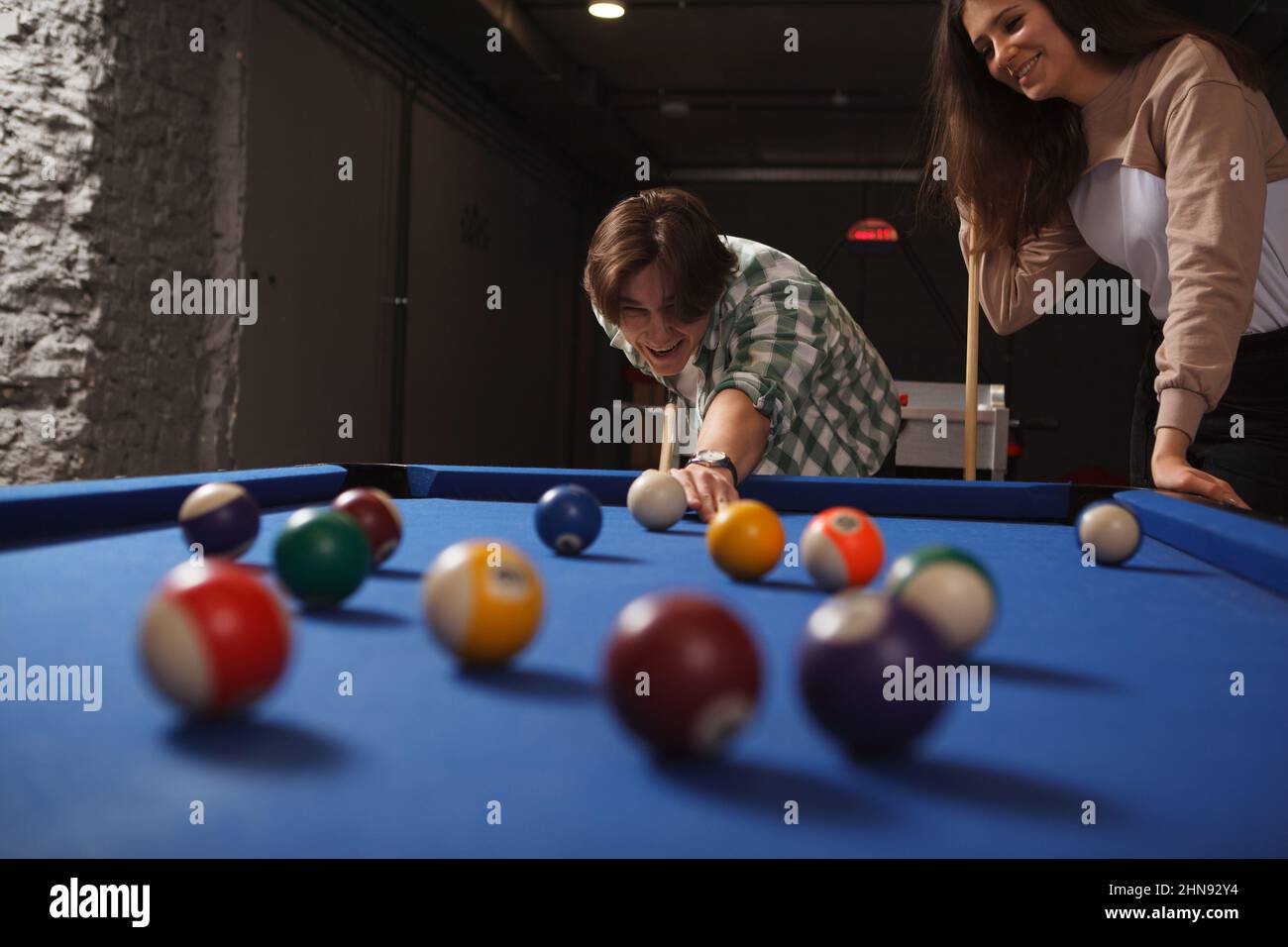 Young people enjoying playing billiard together Stock Photo - Alamy