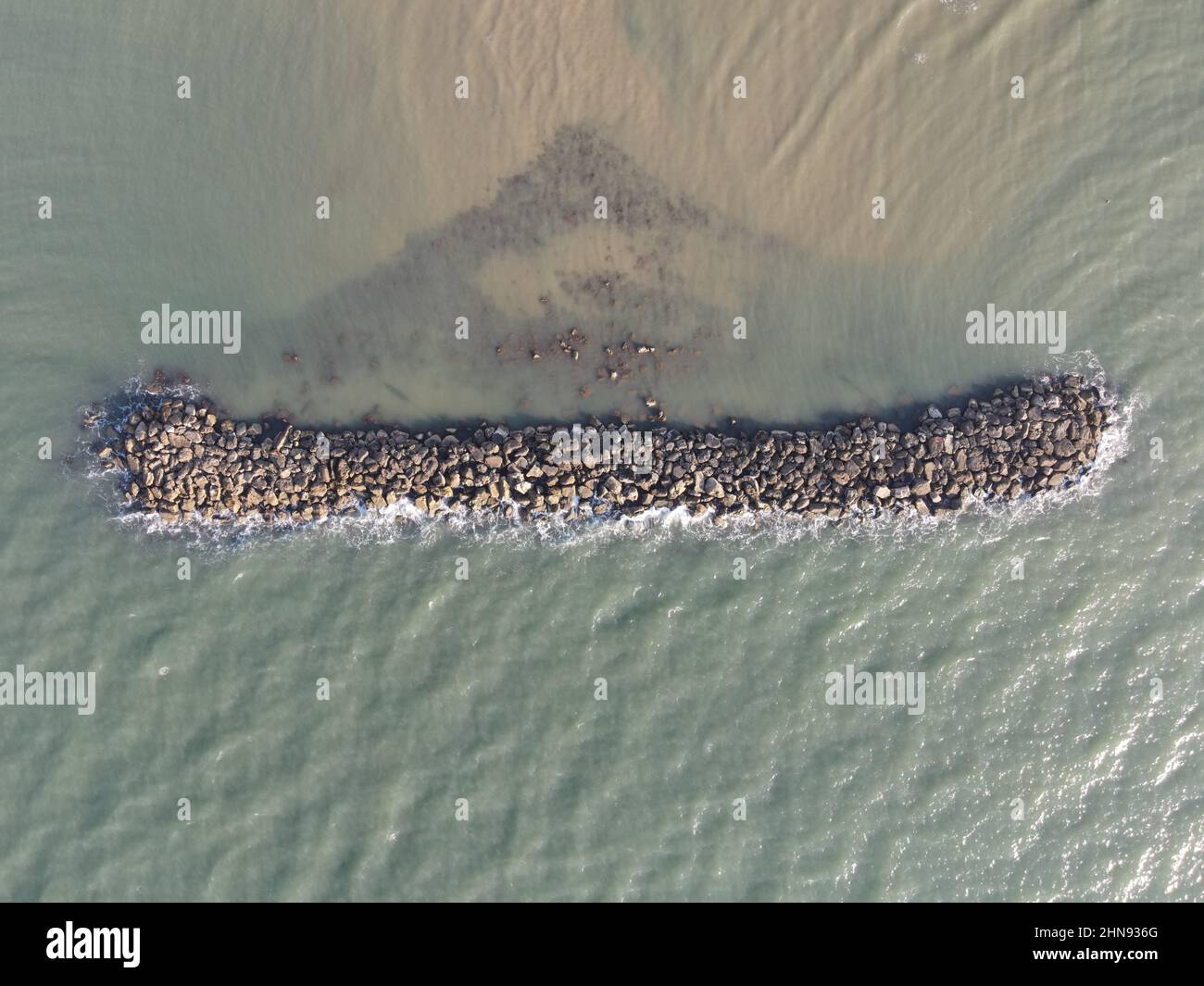 Aerial view of the ocean, rocks and the waves and the reflection of ...
