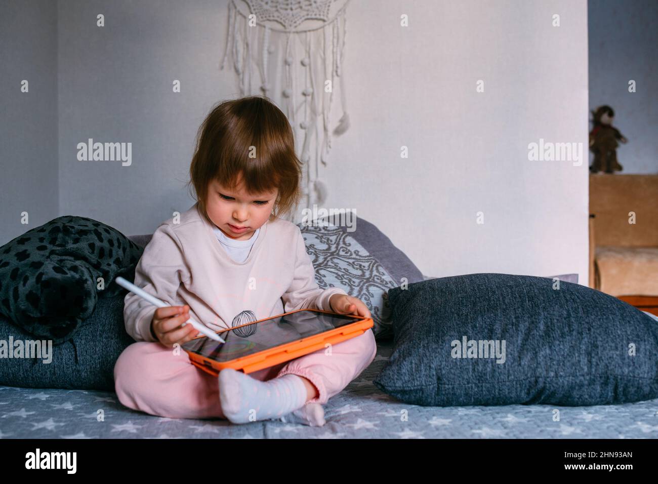 Child using technology. Toddler at home with a tablet and a pen stylus ...