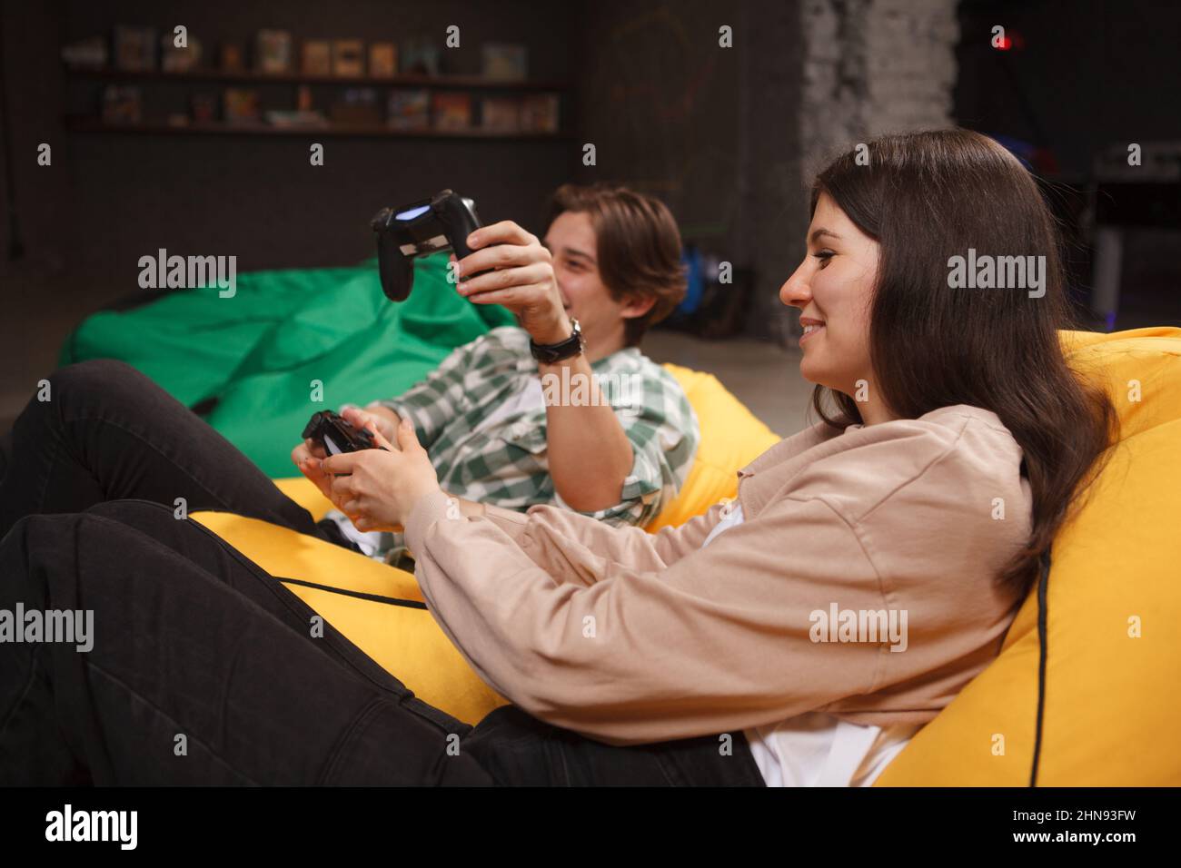 Young beautiful woman smiling, playing video games with her boyfriend ...