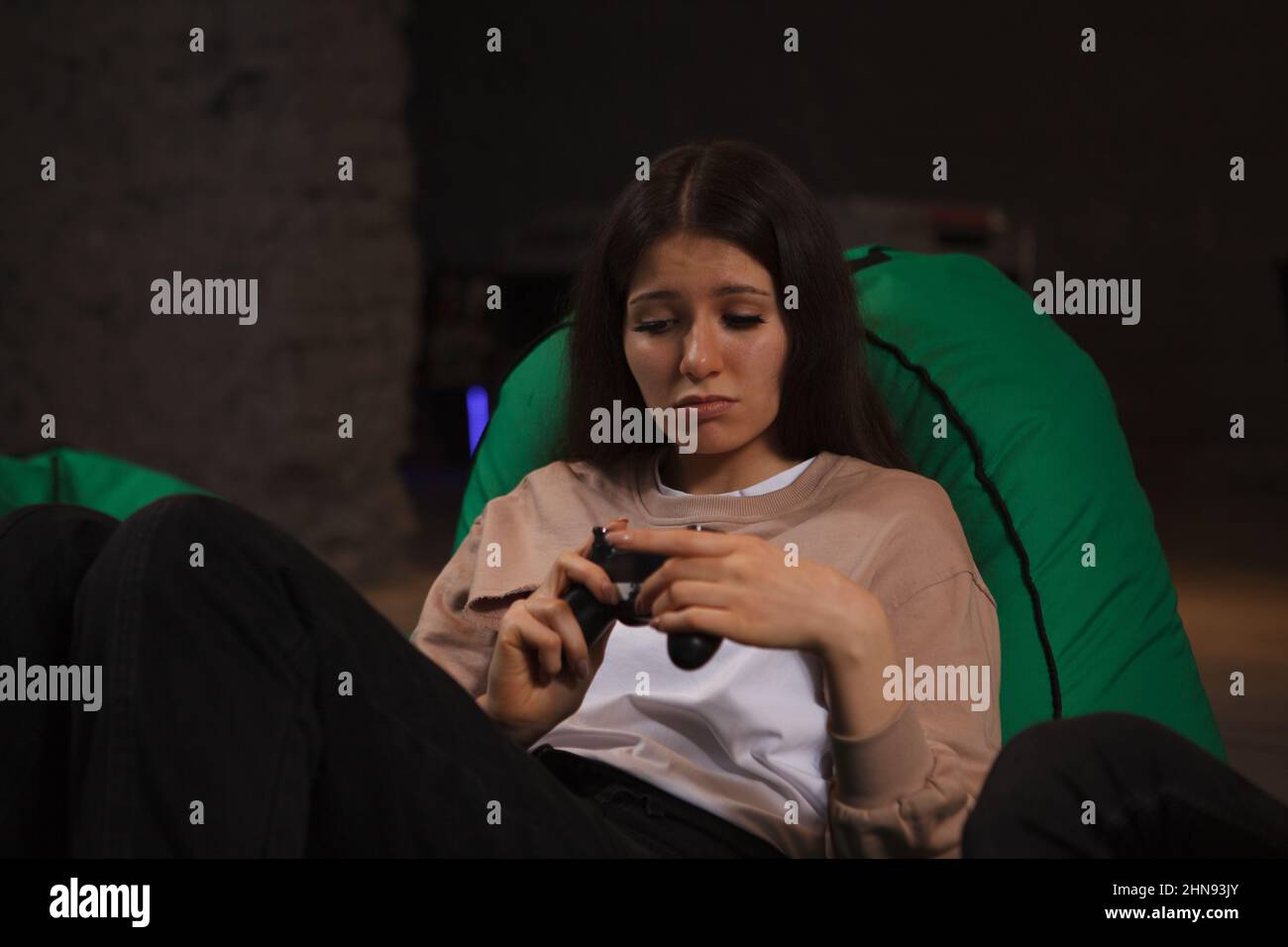 Young woman looking sad after loosing in a video game, holding gamepad ...