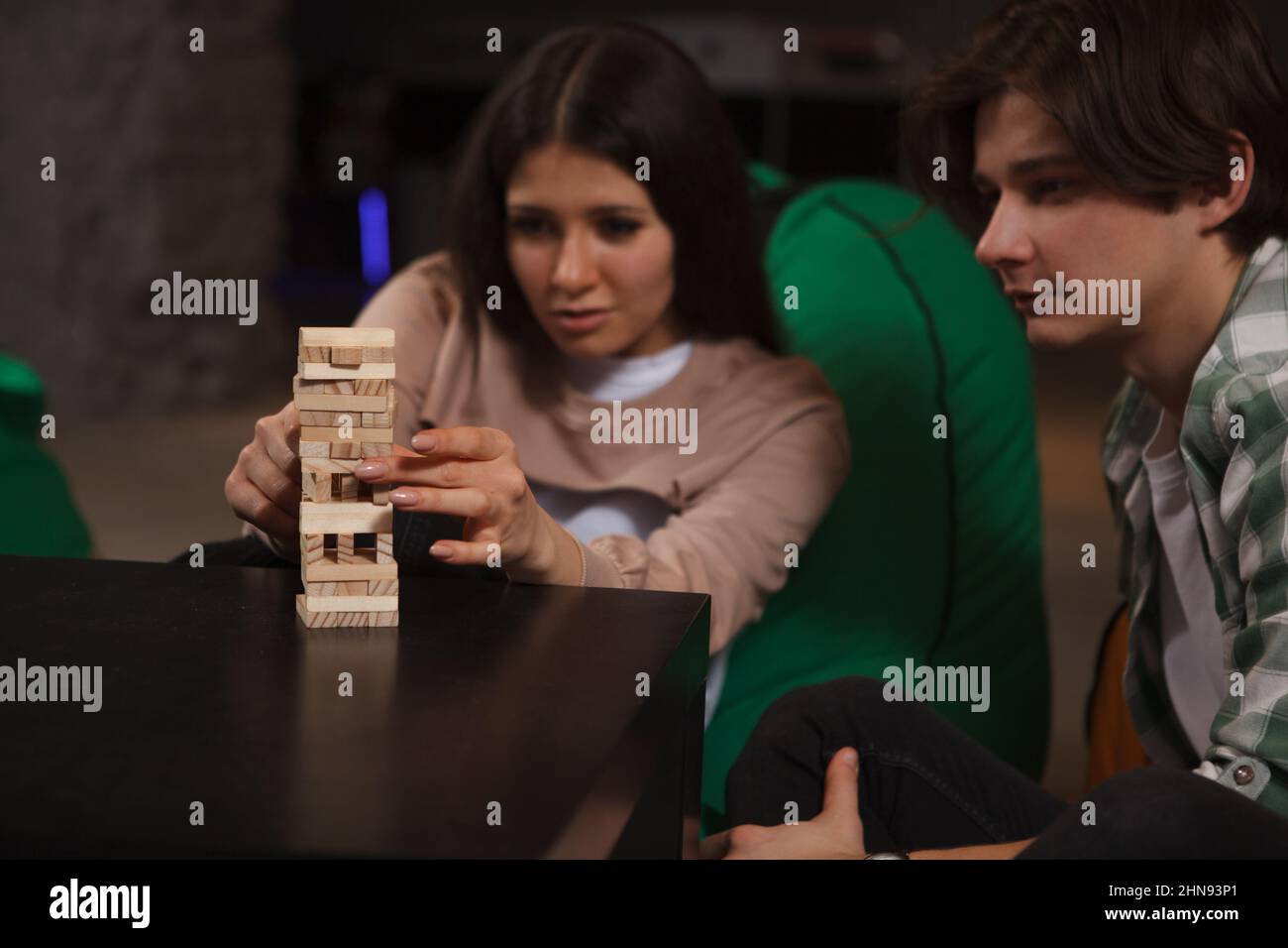 Two friends looking focused, playing jenga blocks Stock Photo - Alamy