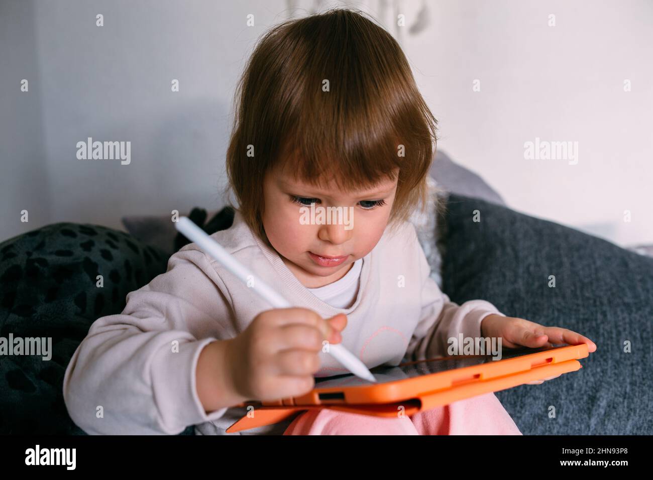 Child using technology. Toddler at home with a tablet and a pen stylus ...