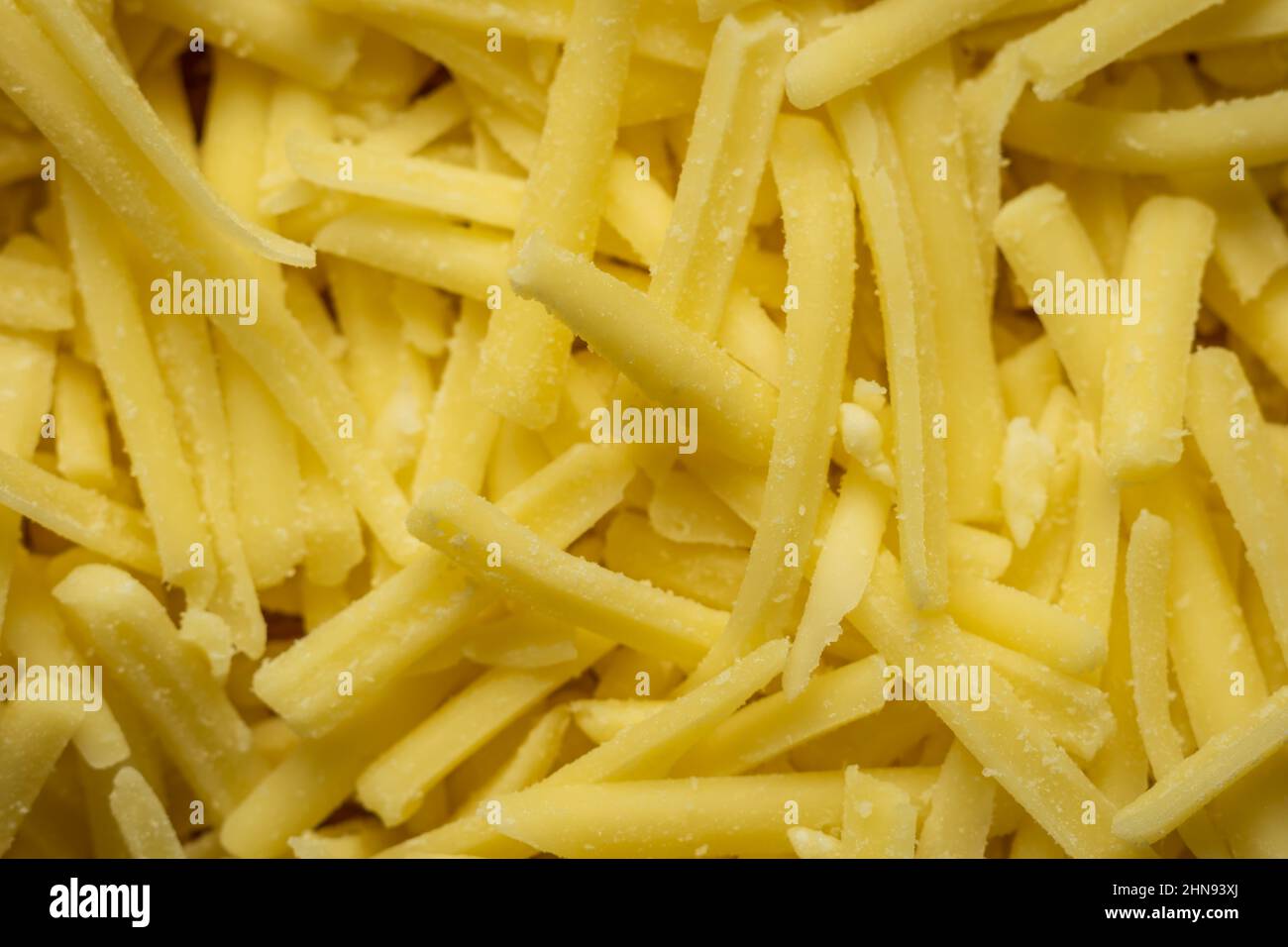 grated cheddar cheese background closeup Stock Photo - Alamy