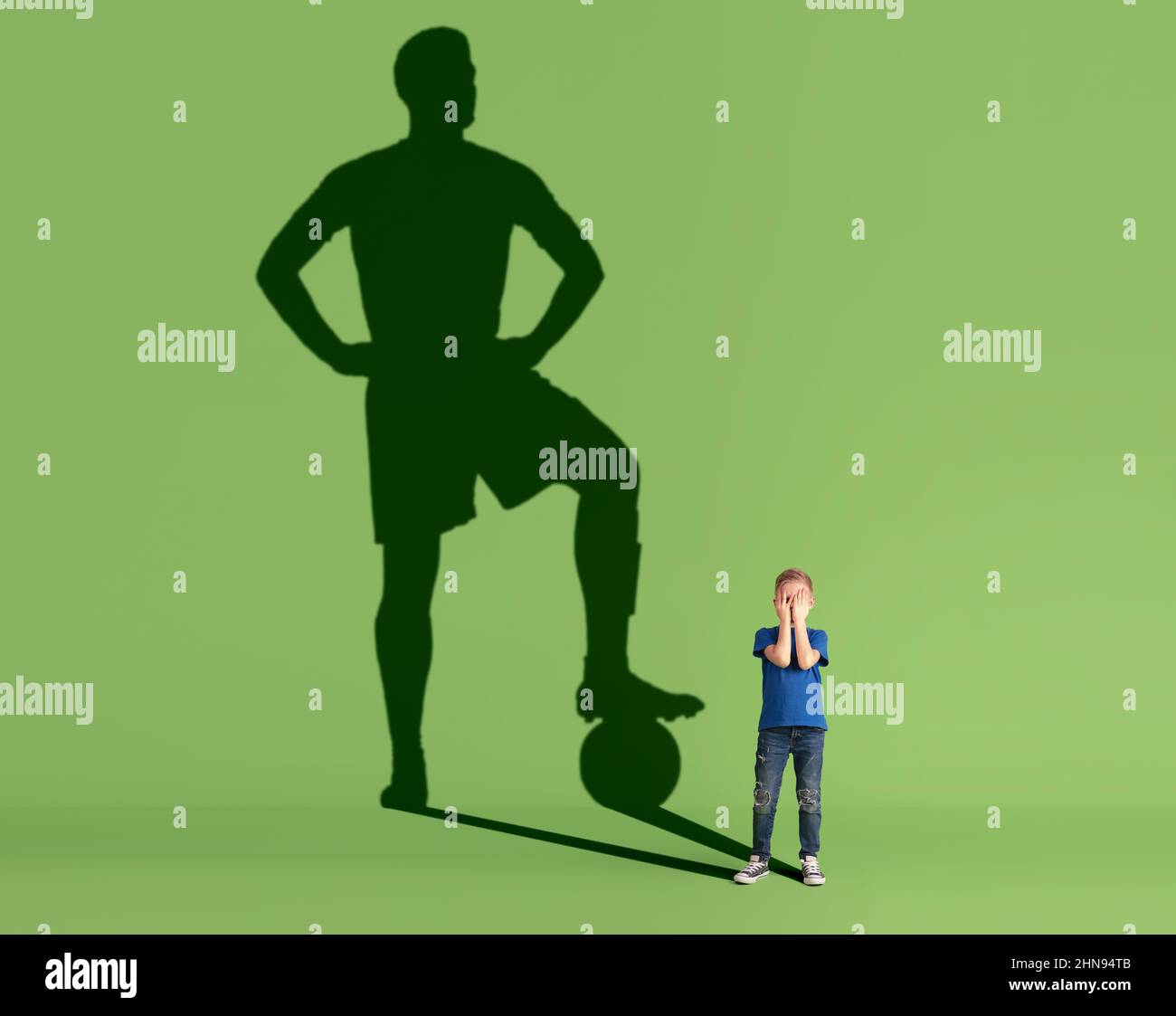 Little boy dreams of becoming a football player isolated on green ...