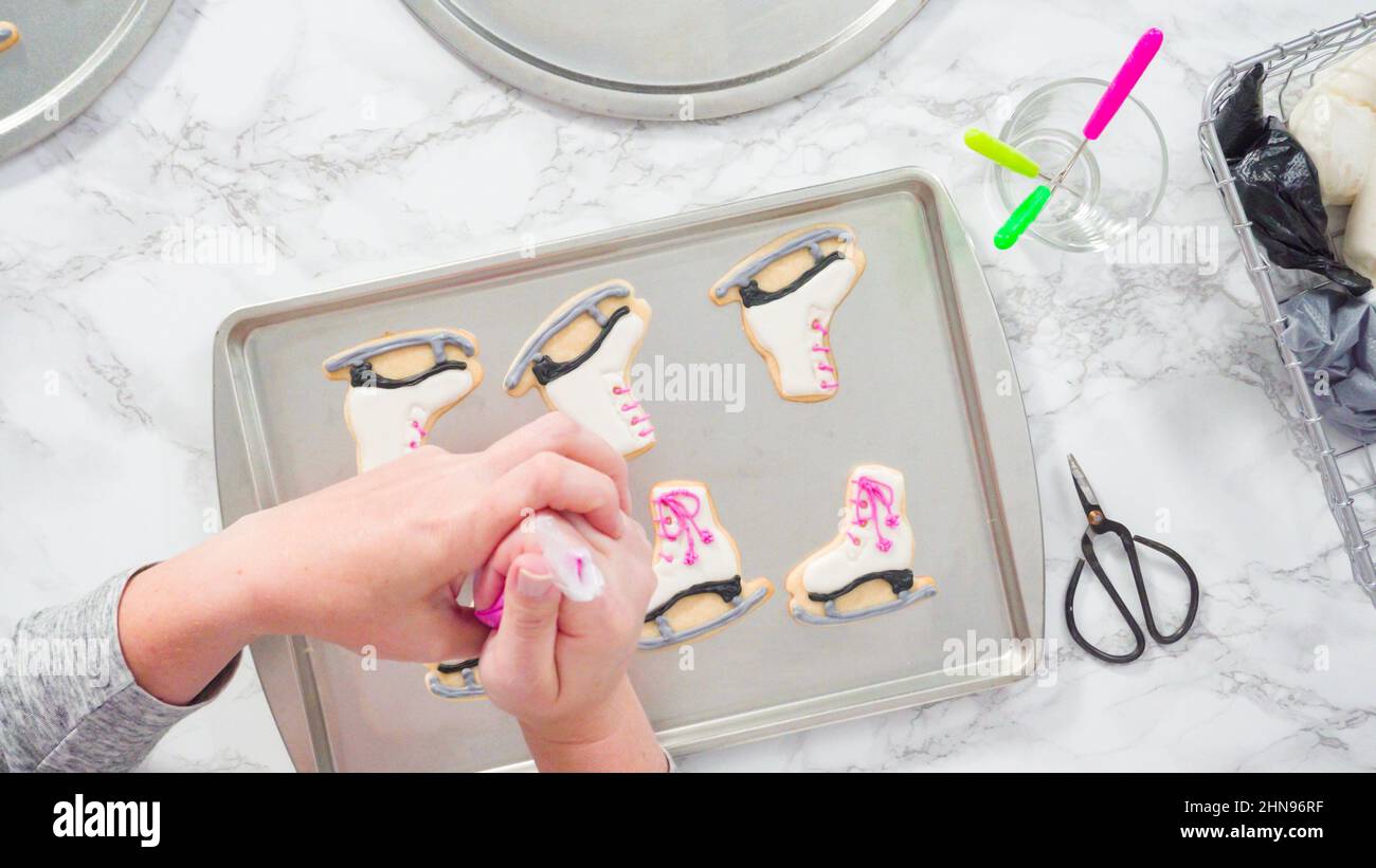 Flat lay. Icing figure skate shaped sugar cookies with royal icing ...