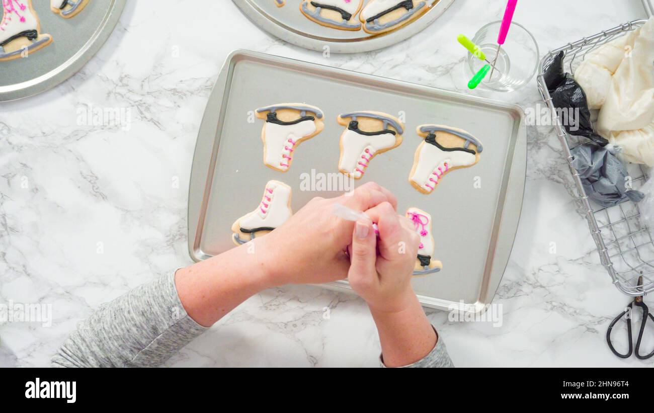 Flat lay. Icing figure skate shaped sugar cookies with royal icing ...