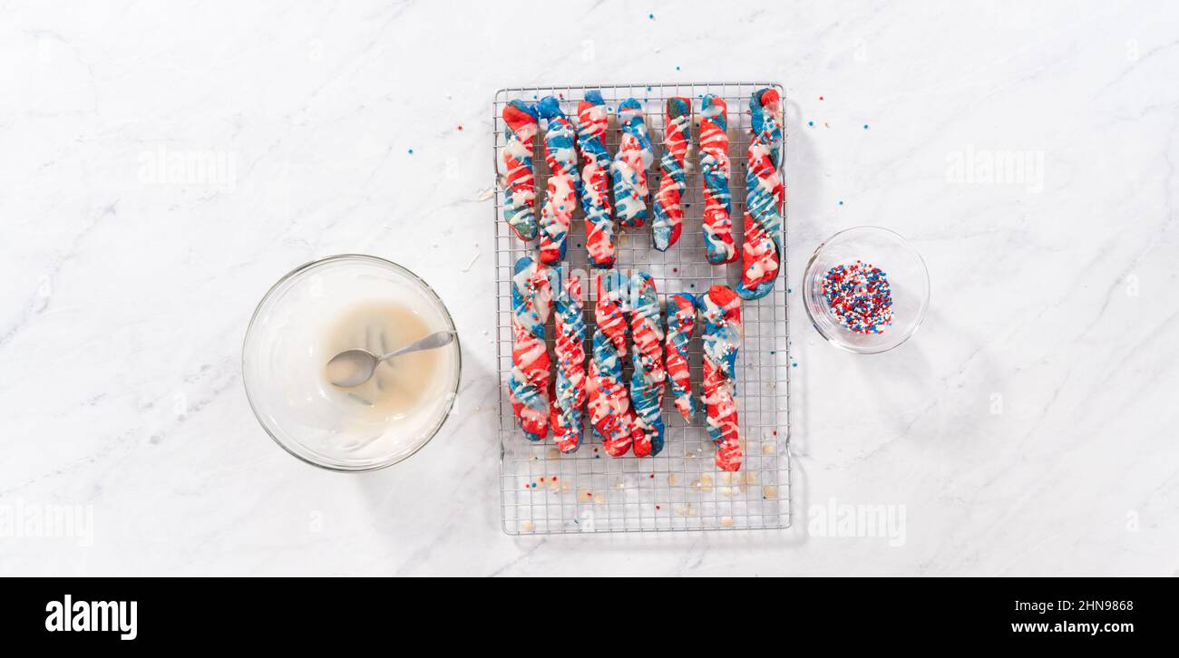 Flat lay. Drizzling white glaze on top of patriotic cinnamon twists and ...