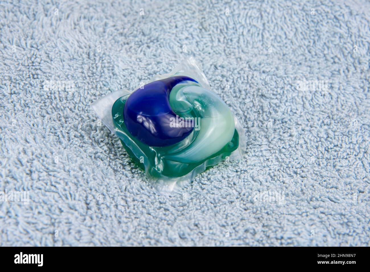 Colorful gel capsule for washing on blue material soft background Stock ...