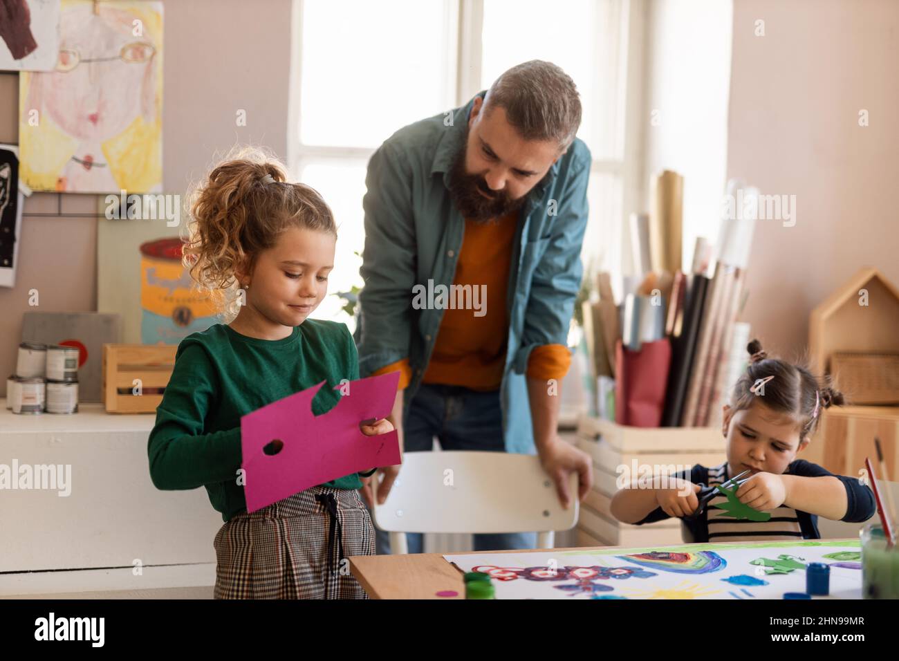 Little kids working on project with teacher during creative art and ...