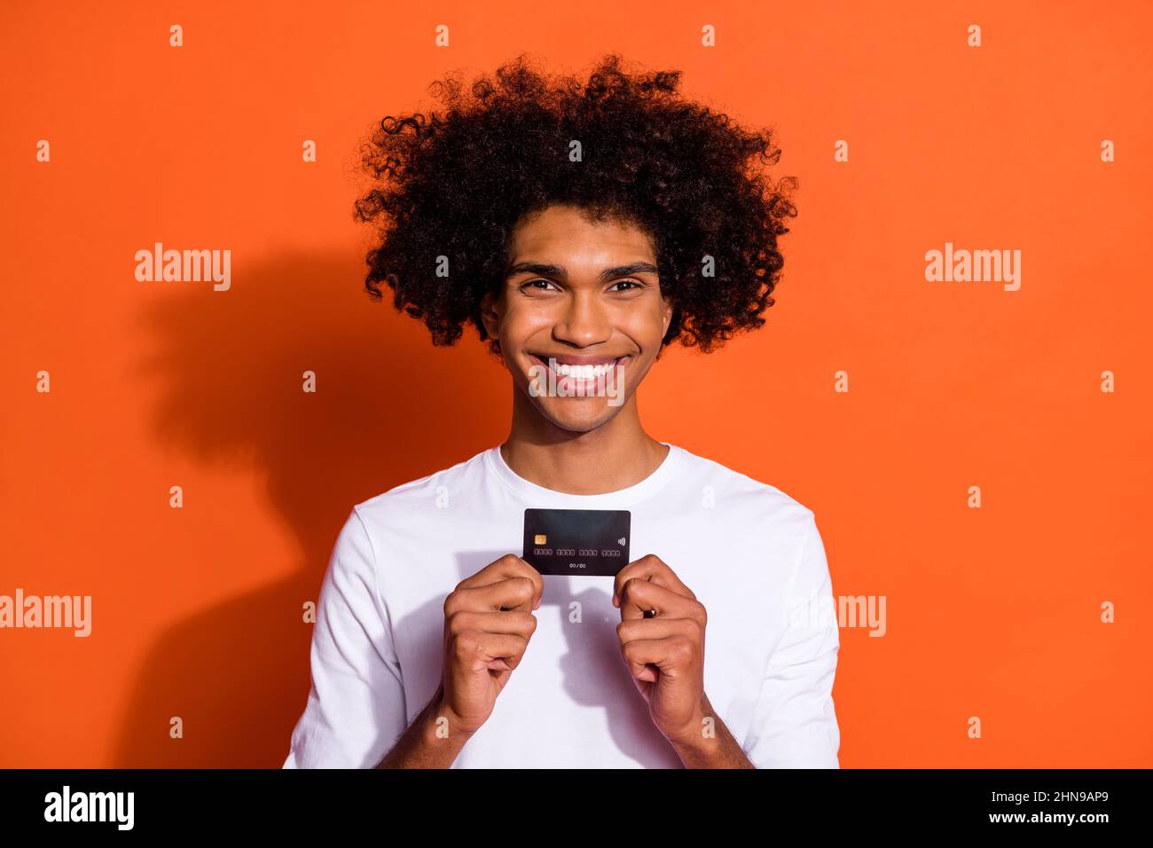 Photo of funny pretty guy wear white shirt smiling buying bank card ...
