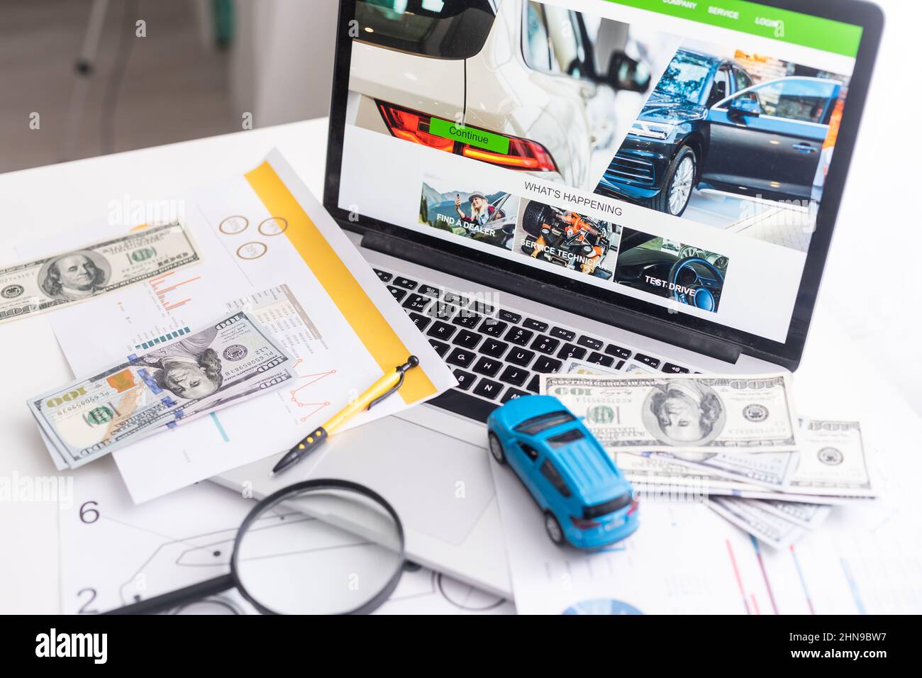 toy car with dollars is on the laptop. The programmer Stock Photo - Alamy