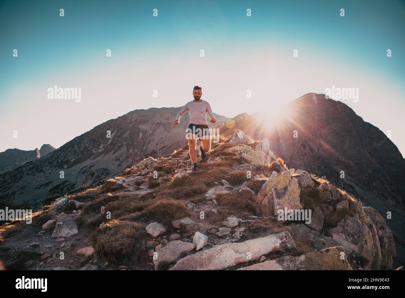 trail runner running in mountain landscape at sunset active lifestyle ...