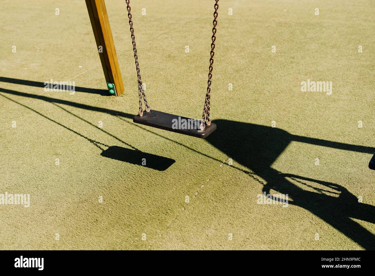 Detail of a swing against artificial grass with hard shadows Stock ...