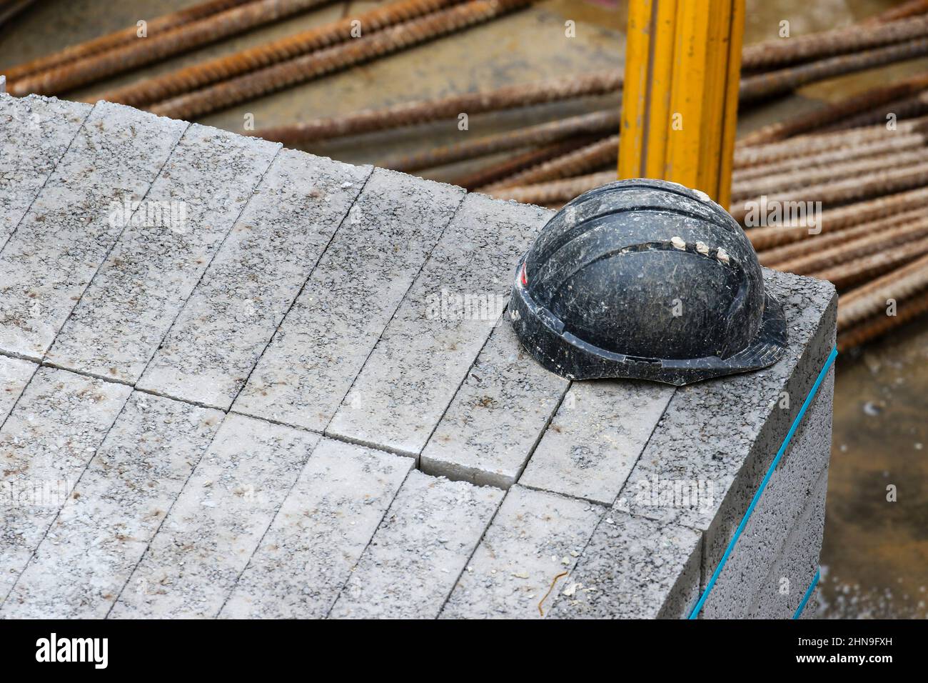 Black hard hat on concrete blocks in construction site. Worn muddy ...