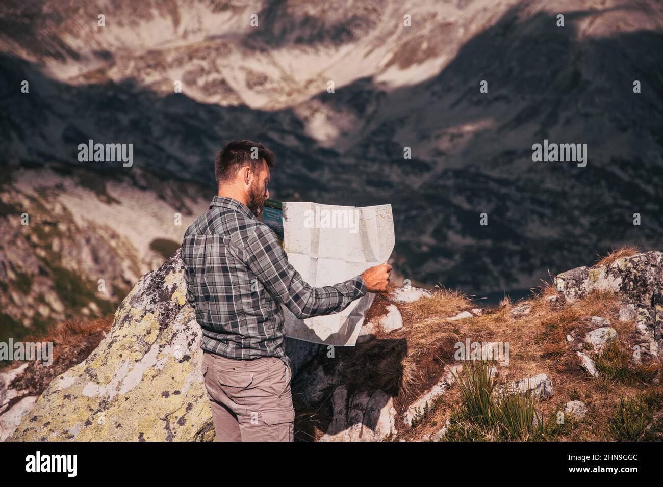 handsome man looking at man on mountain top in amazing summer landscape ...