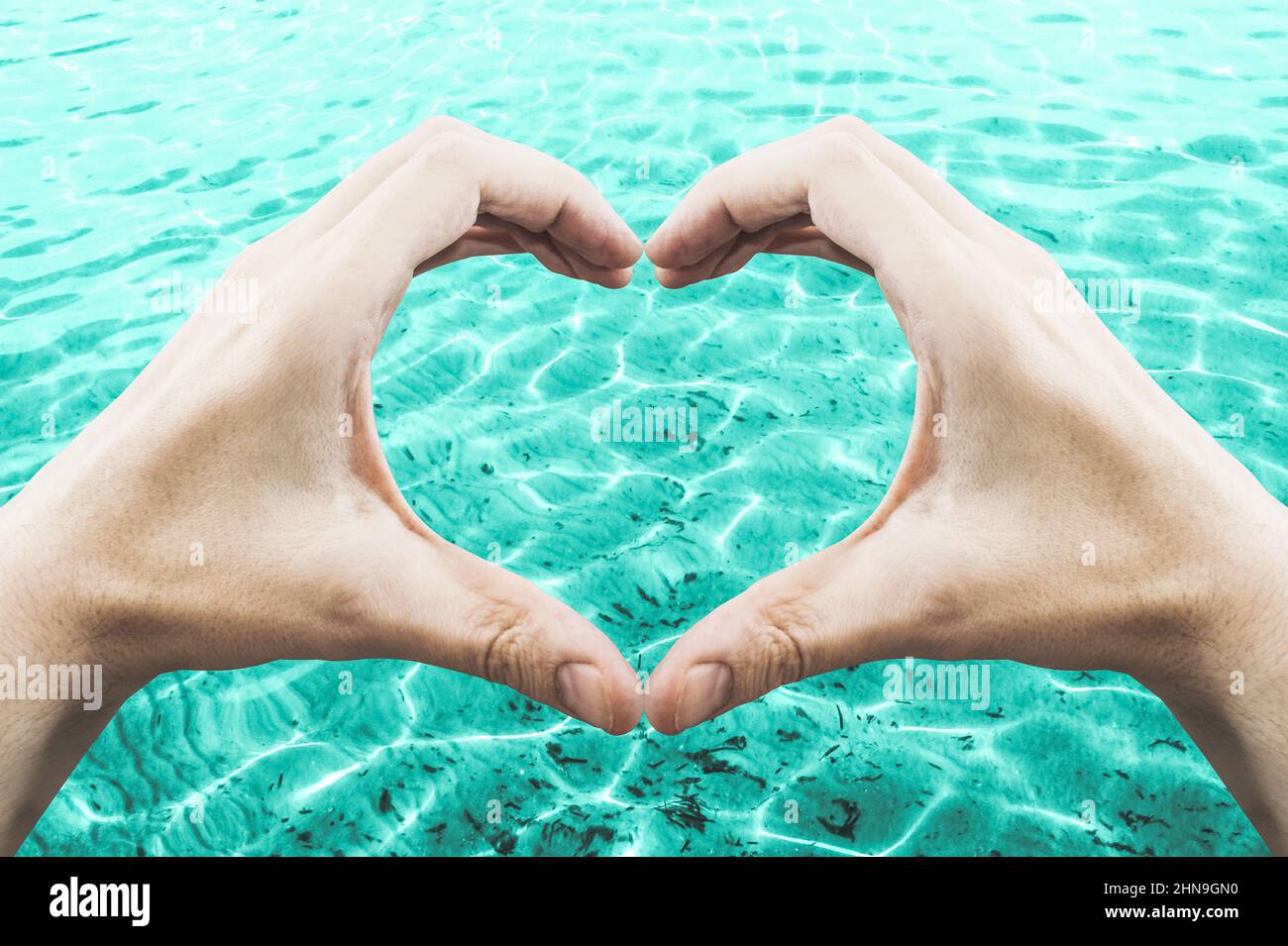 Hands forming heart shape, blue water surface - holiday concept Stock ...