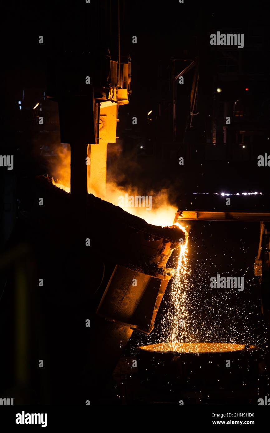 Molten metal pouring from metallurgy ladle. Close-up photo. Black ...