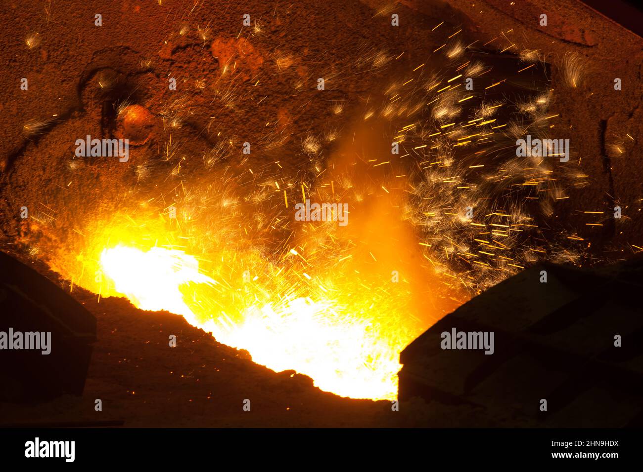 Molten metal in metallurgy ladle. Sparks with trails Stock Photo - Alamy