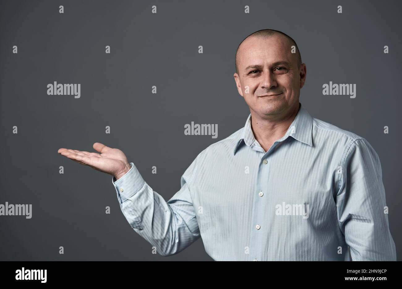 Mature businessman presenting an invisible product to the side of the ...