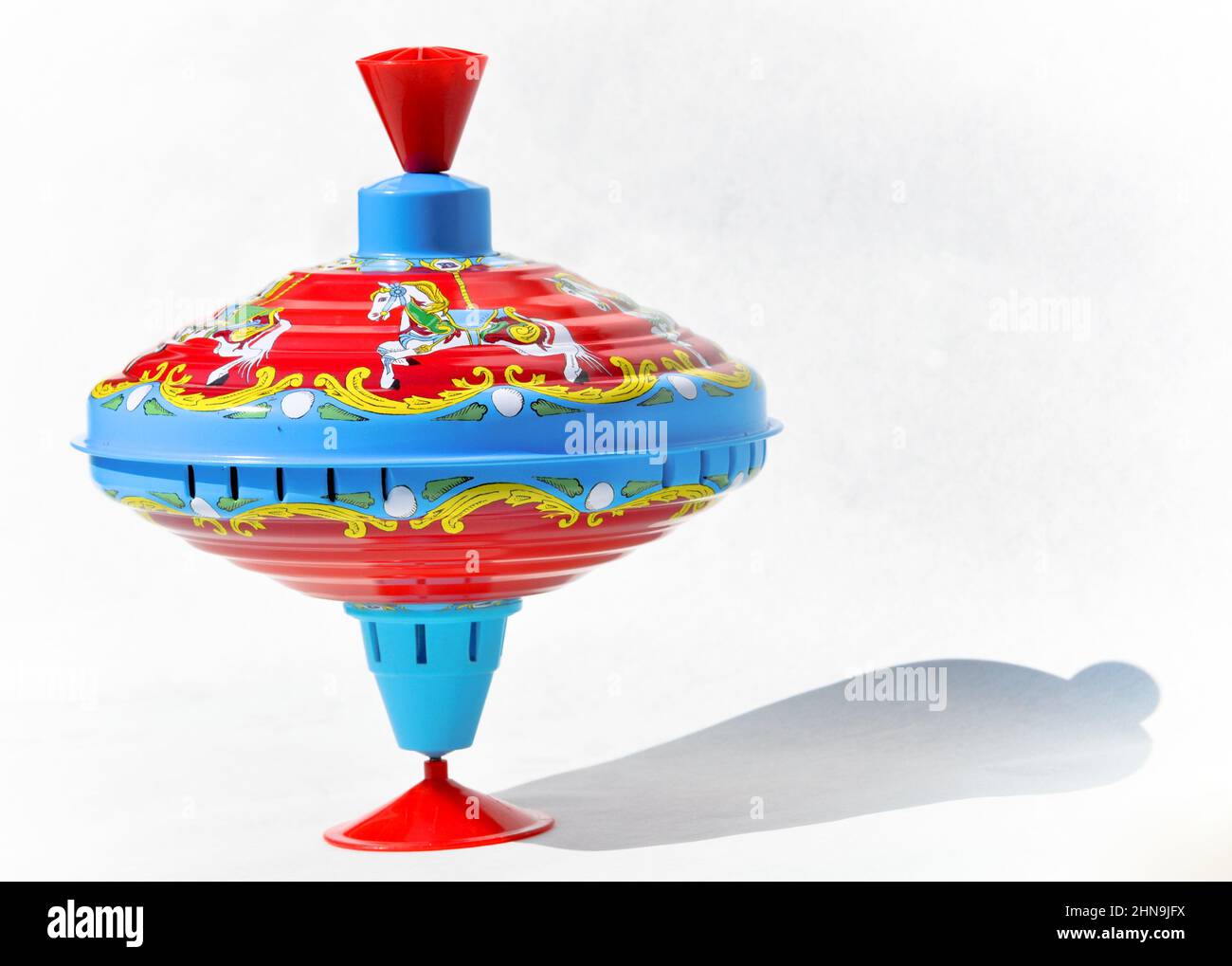 A child's metal spinning top (humming top) with a horse design in red ...