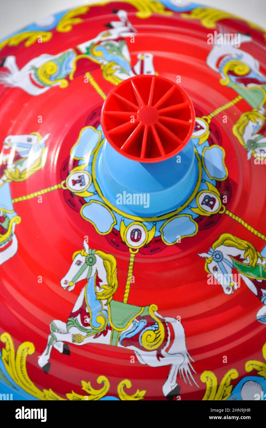 A child's metal spinning top (humming top) with a horse design in red ...